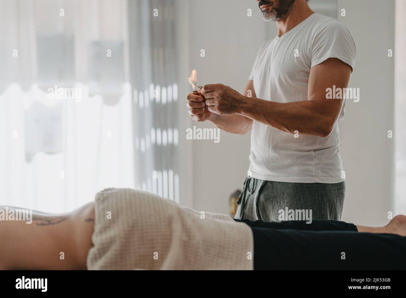 physiotherapist setting fire to absorbent cotton to warm up the suction ...