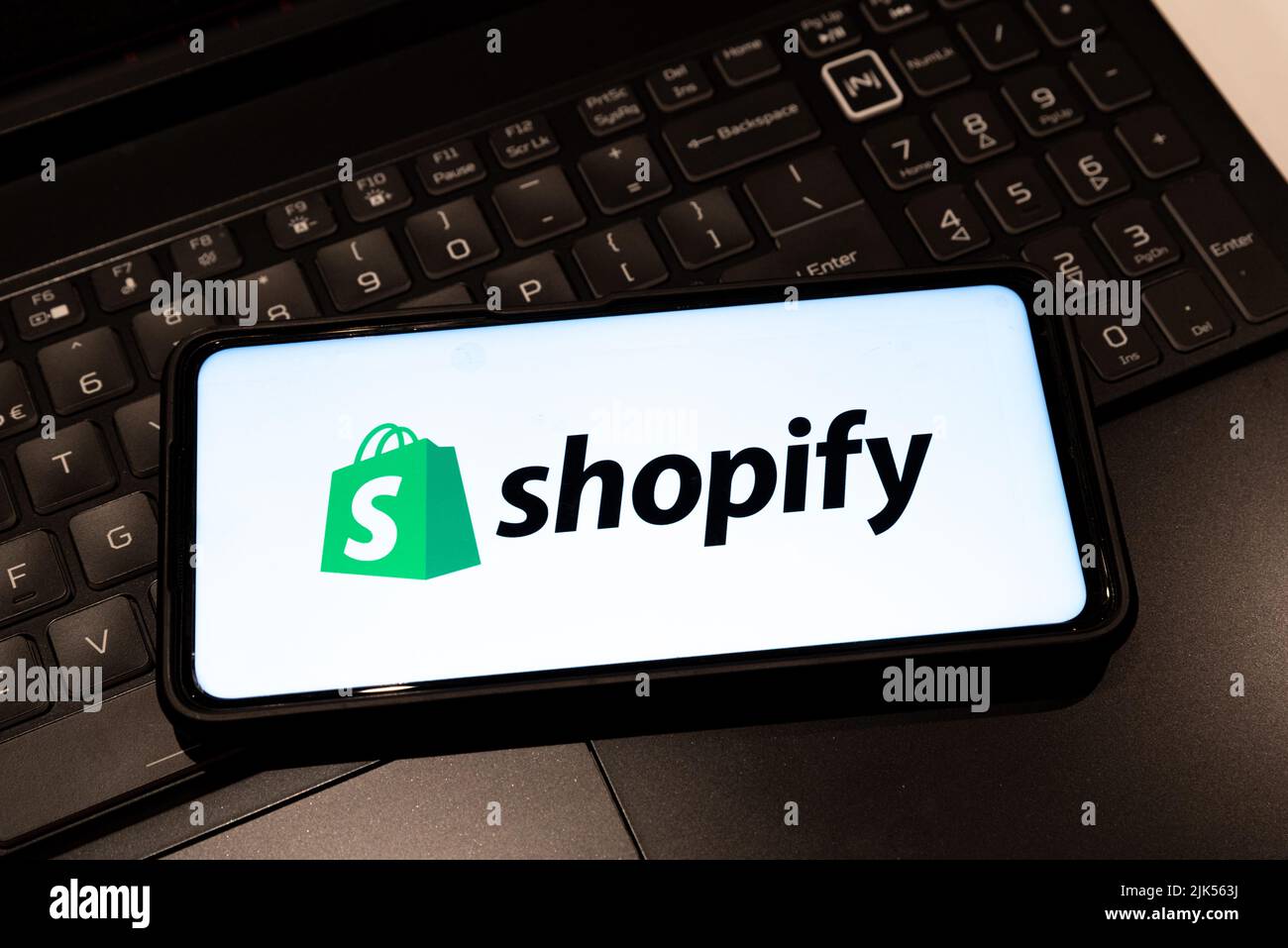 Shopify logo on smartphone screen , background is a keyboard , Sydney ...