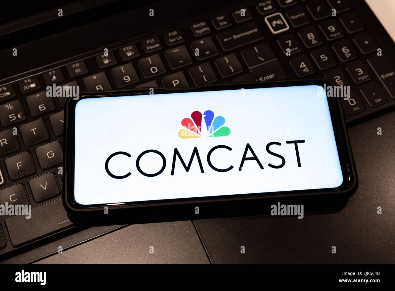 Comcast logo on mobile phone , background is a keyboard , Sydney ...