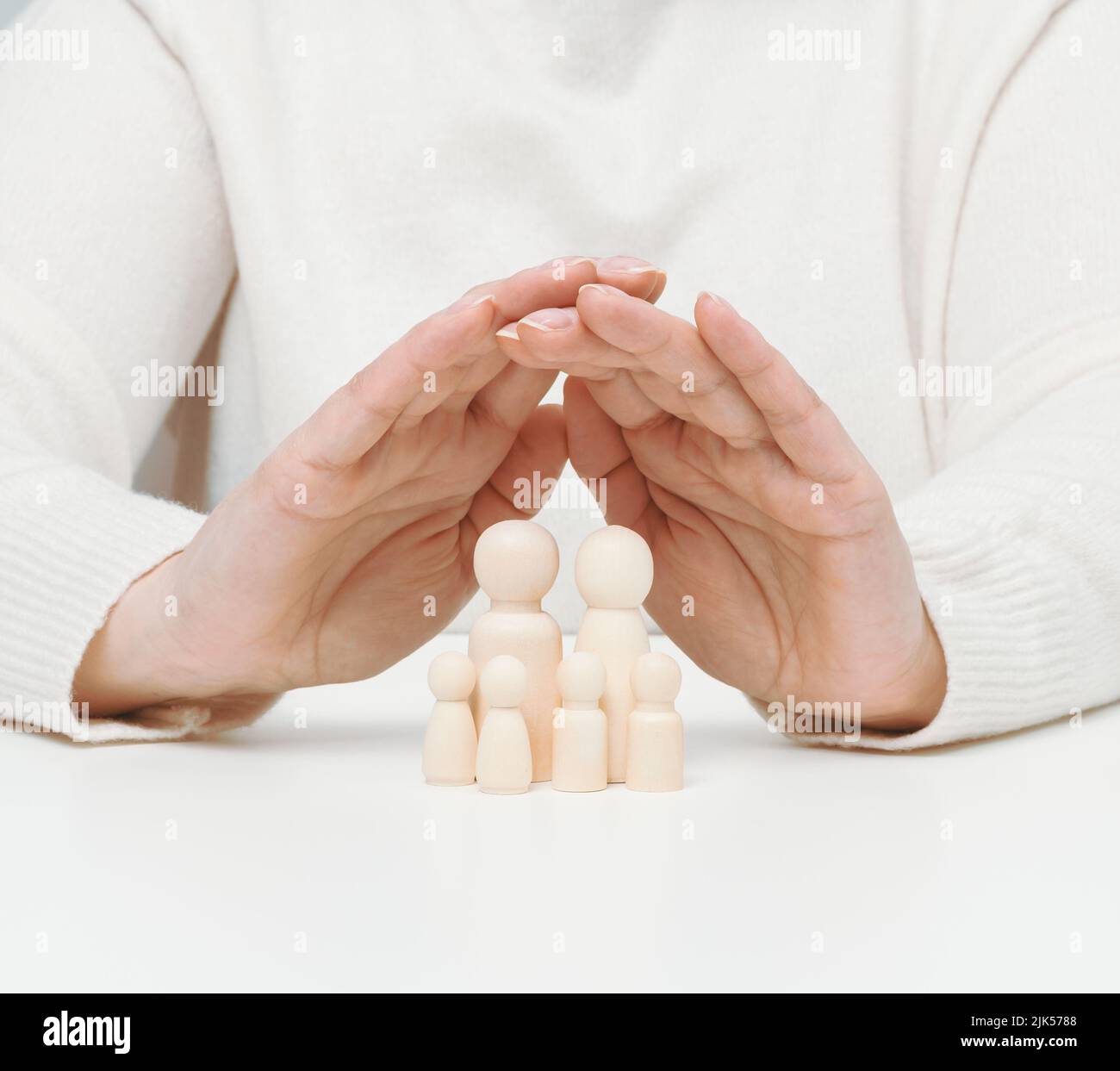Wooden figurines of men, a family guarded by two female hands. Help ...