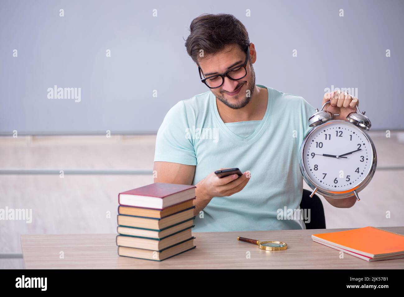Young student in time management concept in the classroom Stock Photo ...