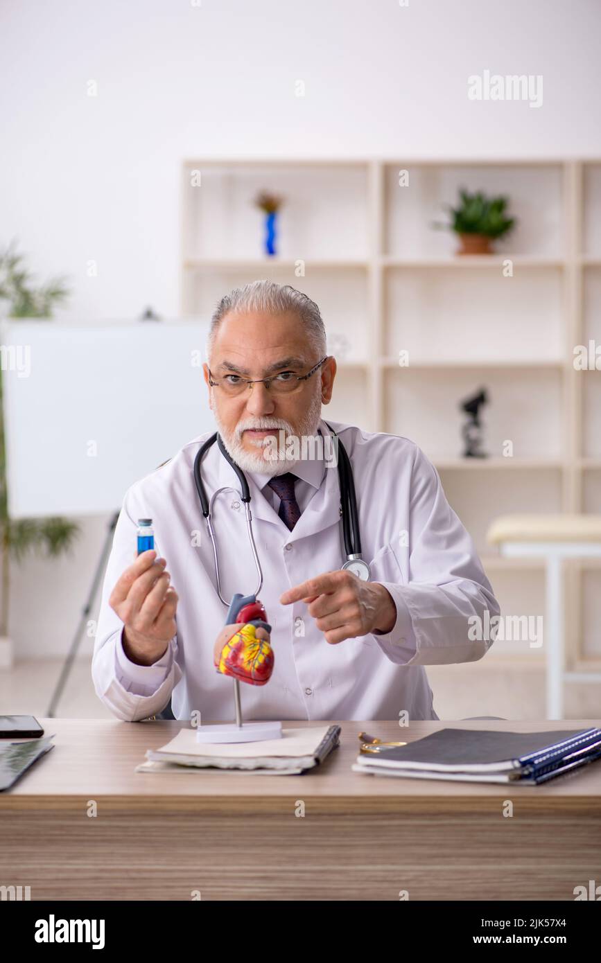 Old doctor cardiologist working in the clinic Stock Photo - Alamy