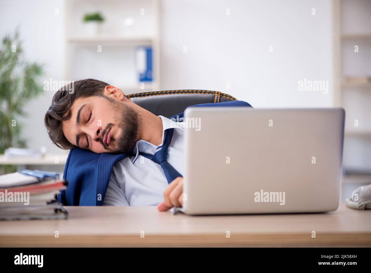 Young businessman employee extremely tired at workplace Stock Photo - Alamy
