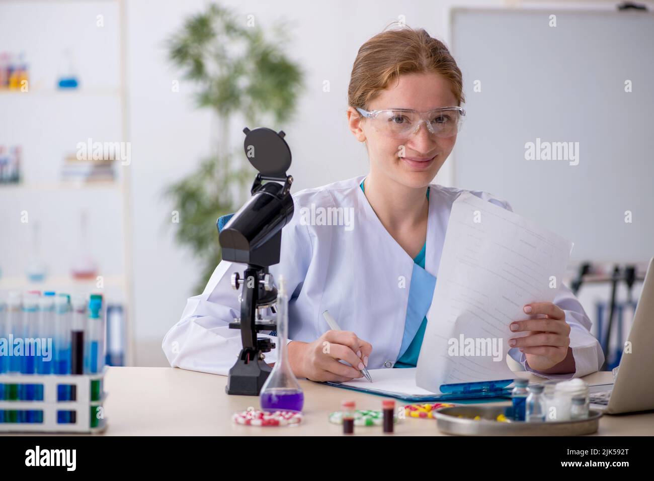 Young girl chemist in drugs synthesis concept Stock Photo - Alamy