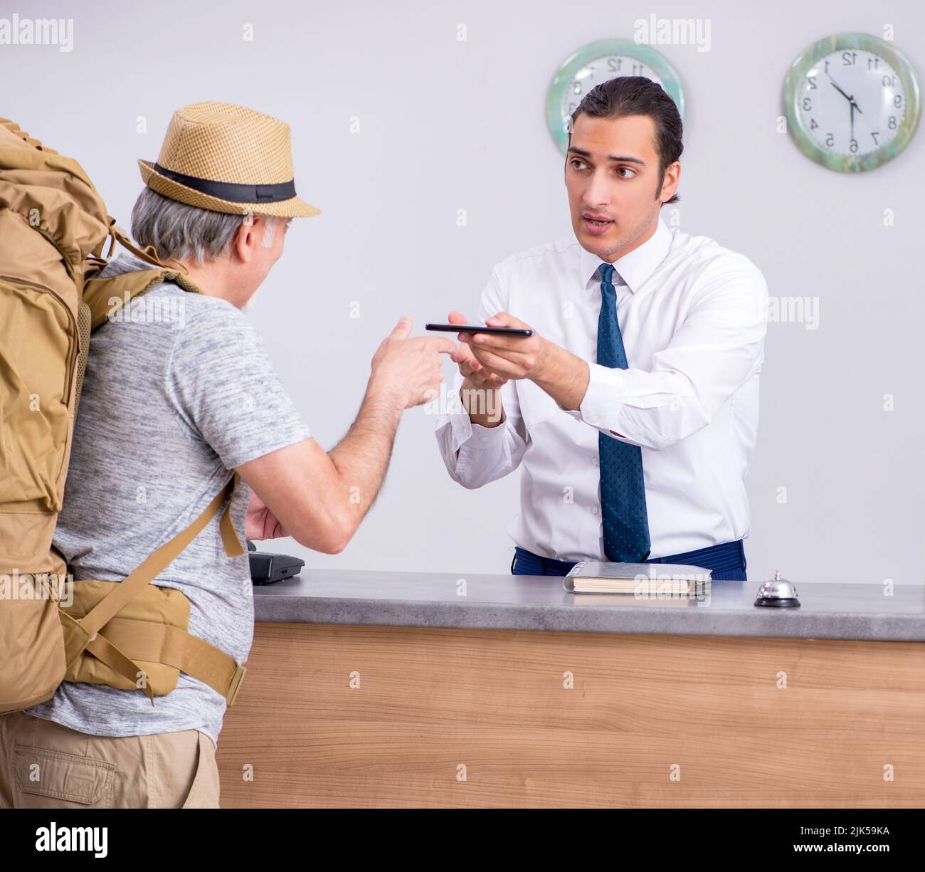 Old backpacker at the hotel reception Stock Photo - Alamy