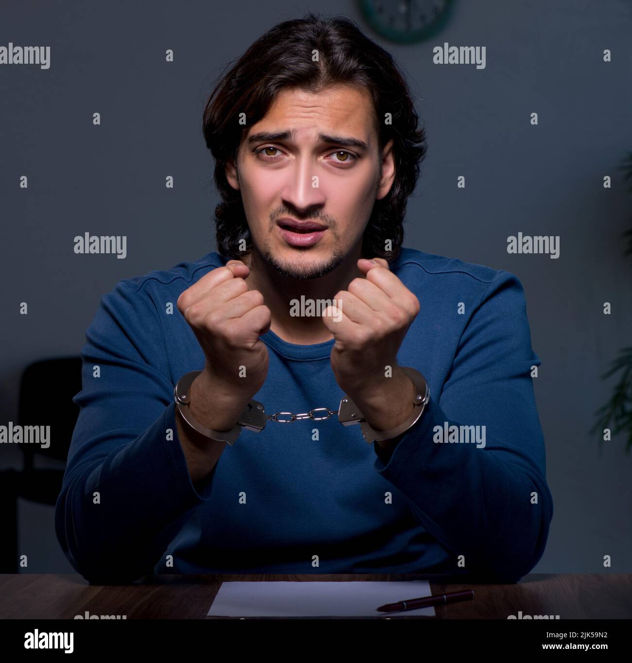 The young convict man sitting in dark room Stock Photo - Alamy