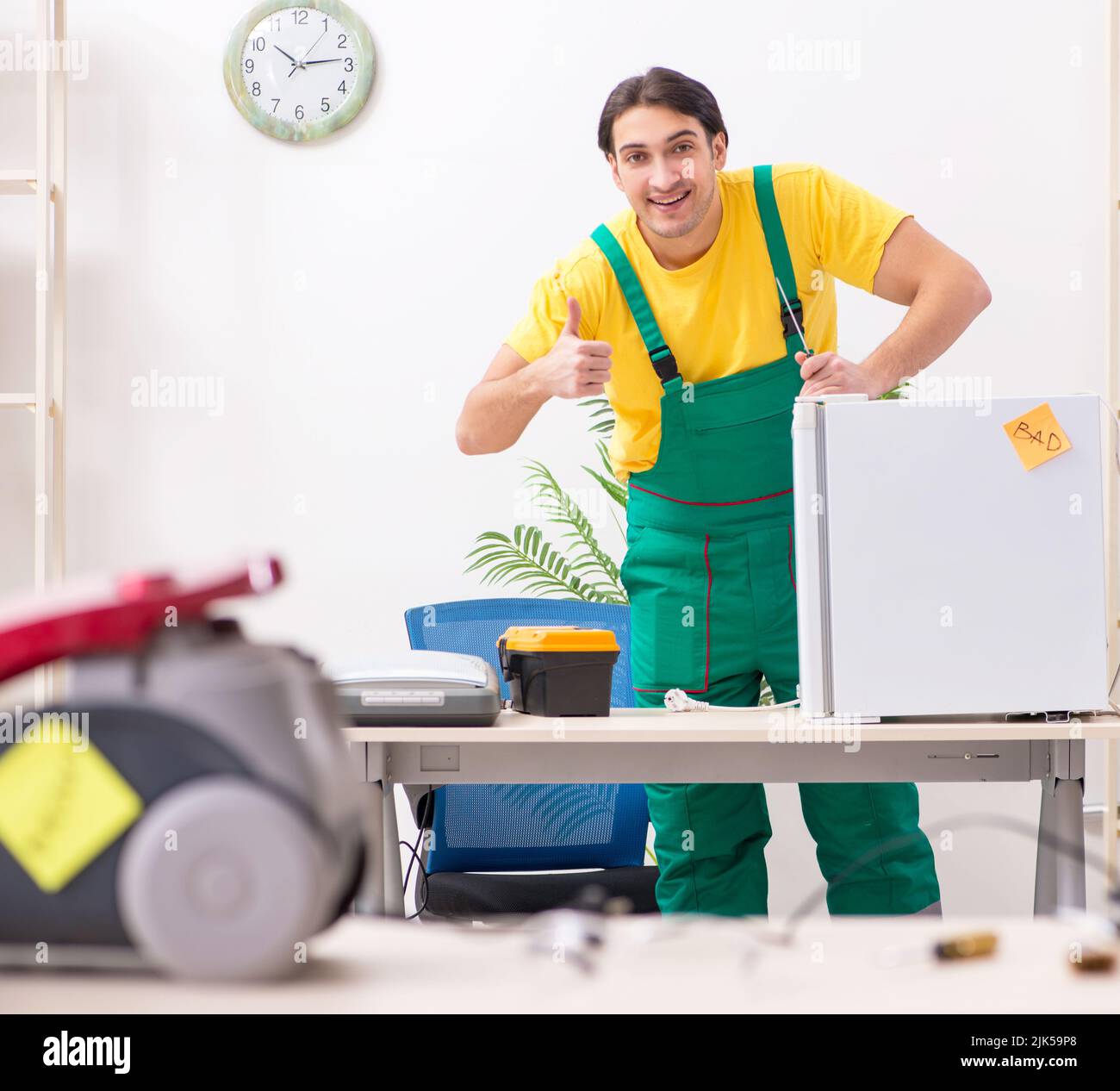 The man repairman repairing vacuum cleaner and fridge Stock Photo - Alamy