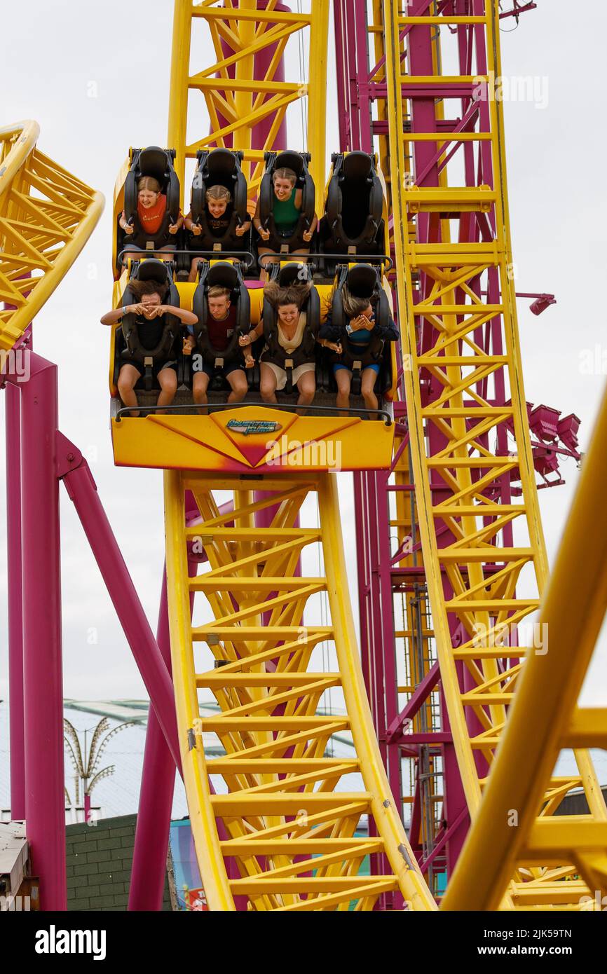 Roller coaster tracks and people in a rollercoaster car speeding ...