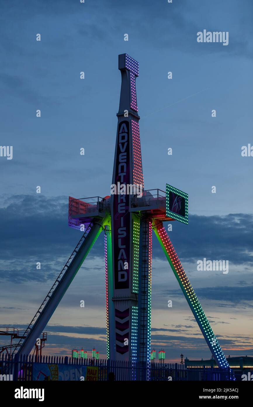 A Pendulum ride roller coaster lit up with multi color light bulbs at ...