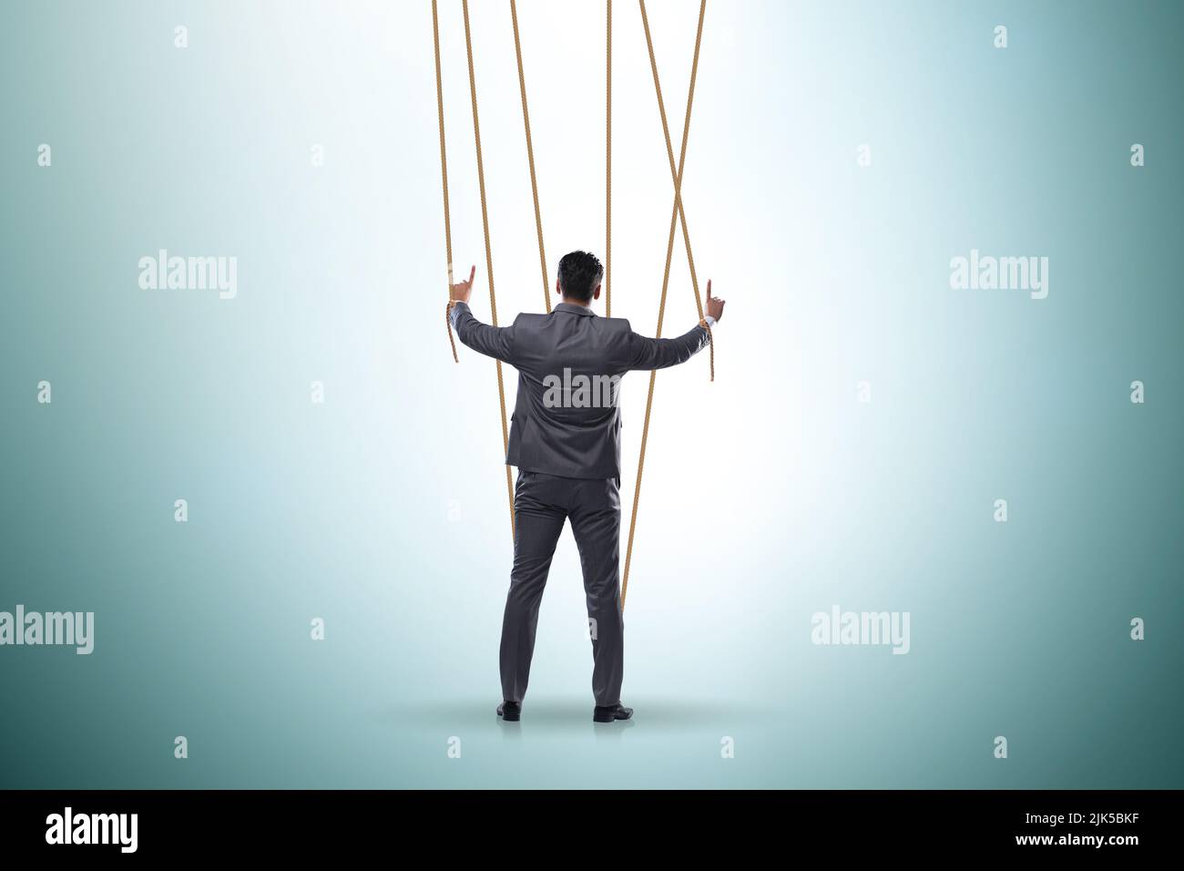 Businessman puppet being manipulated by the ropes Stock Photo - Alamy