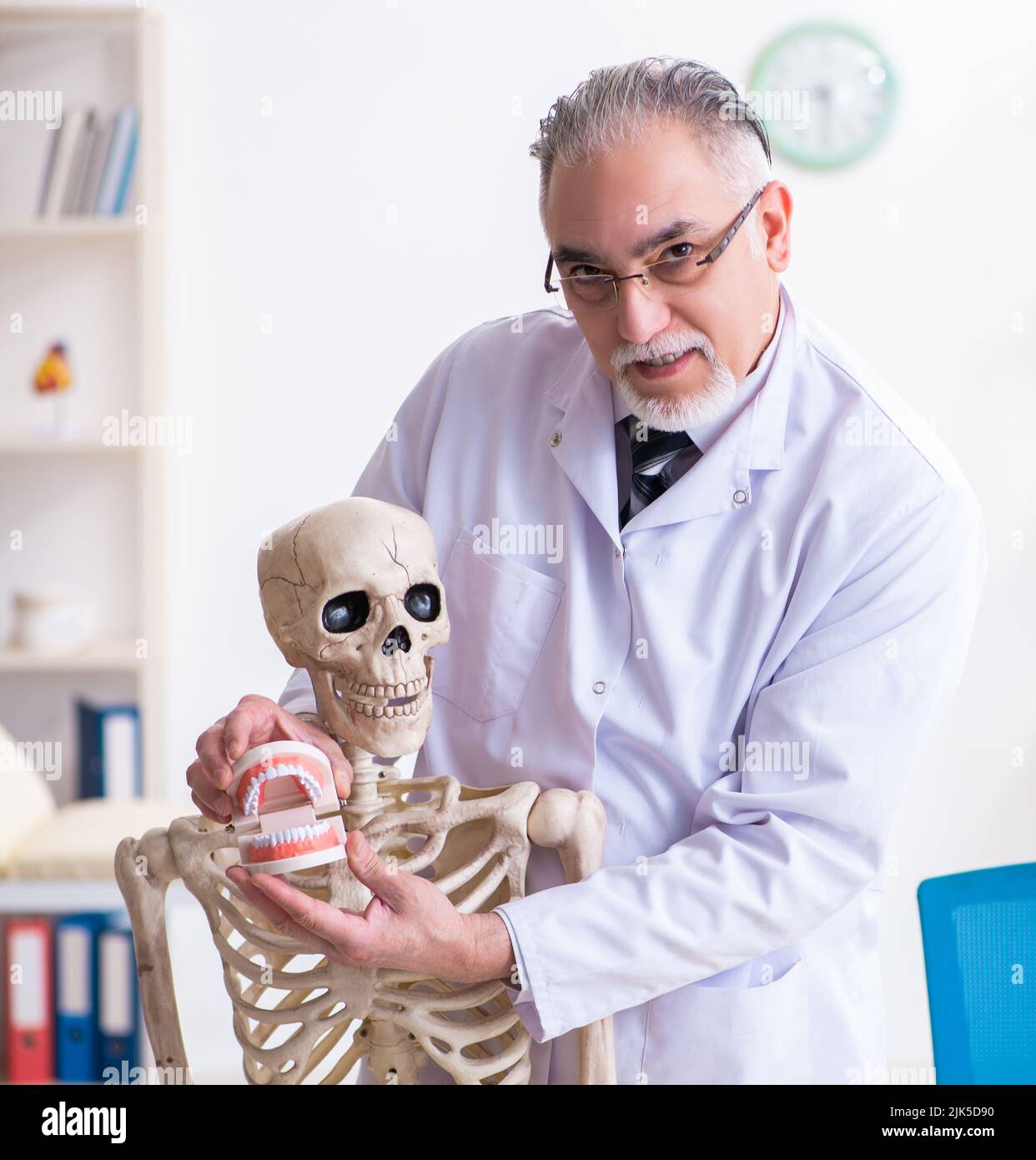 The aged male doctor with skeleton Stock Photo - Alamy