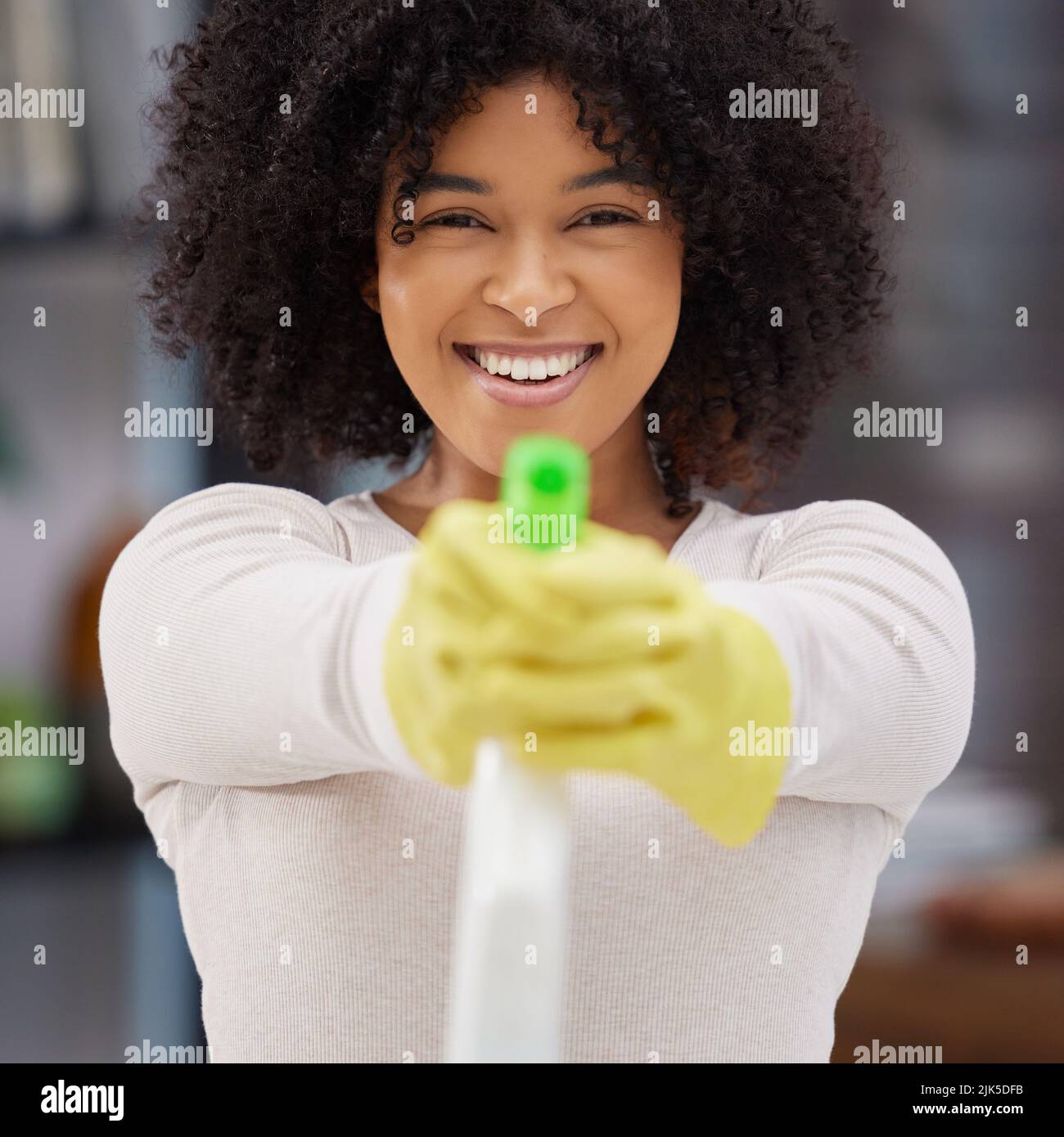 Hands up germs. an attractive young woman standing alone and spraying a ...