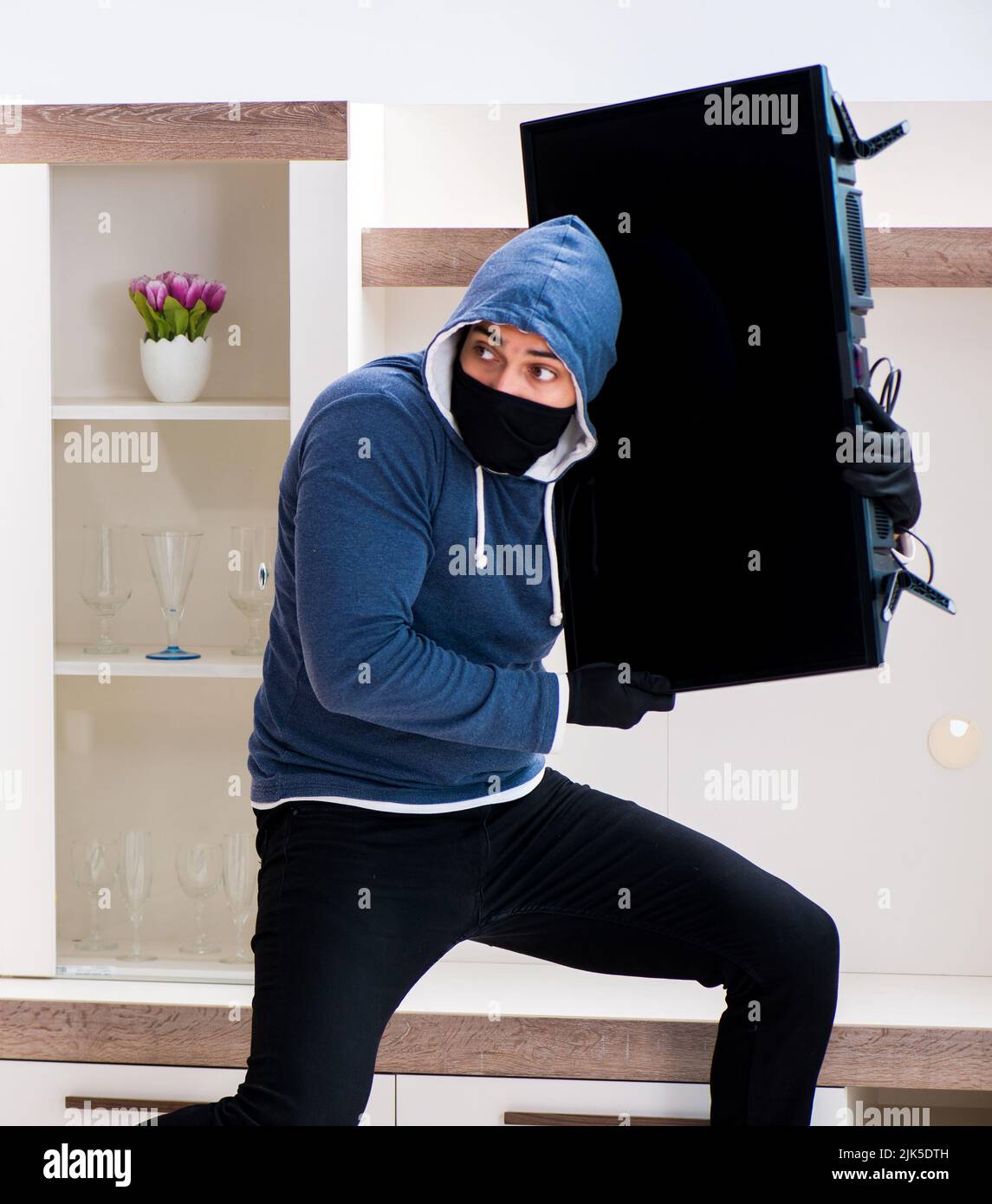 The man burglar stealing tv set from house Stock Photo - Alamy