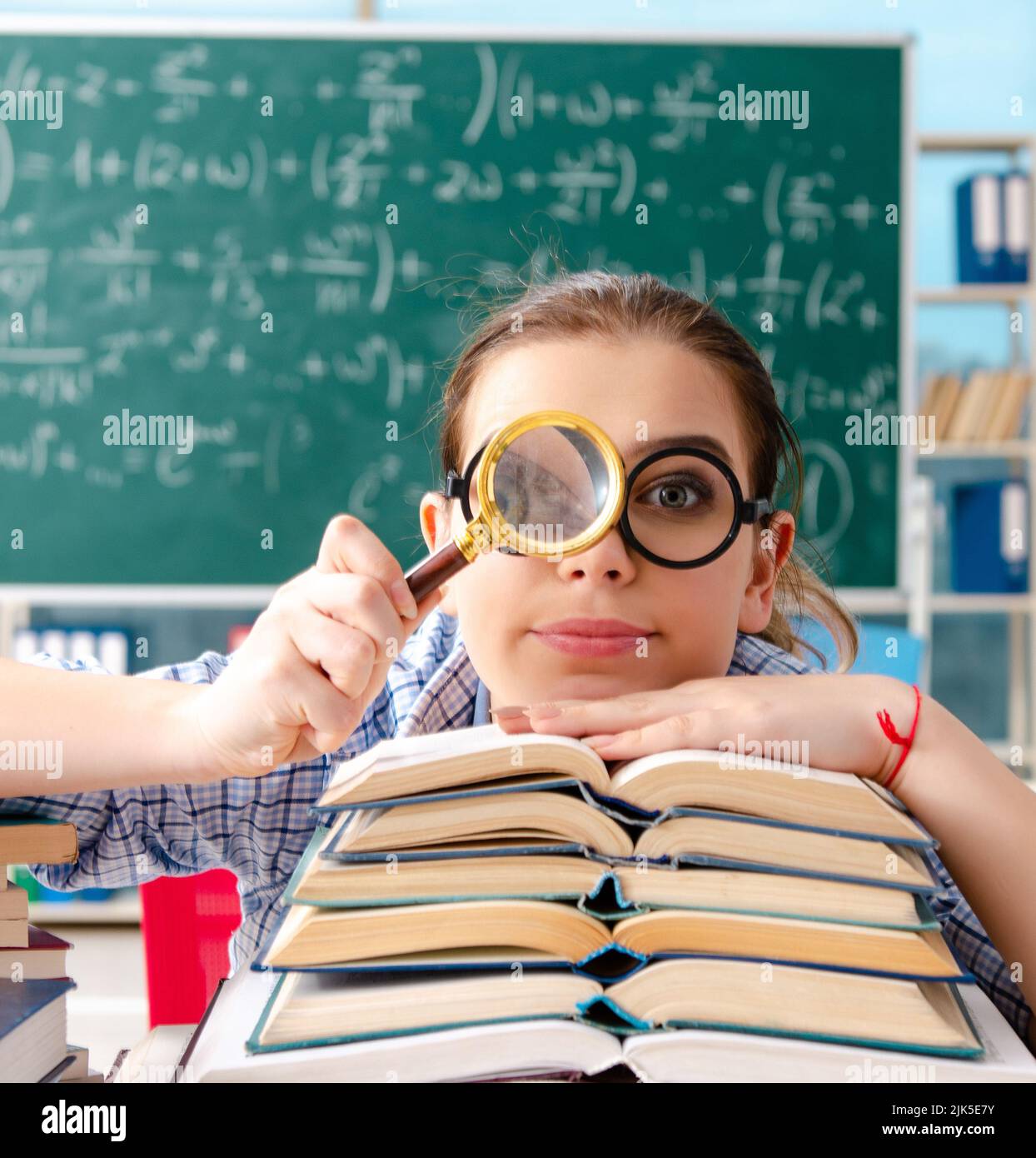 Female student with many books sitting in the classroom Stock Photo - Alamy