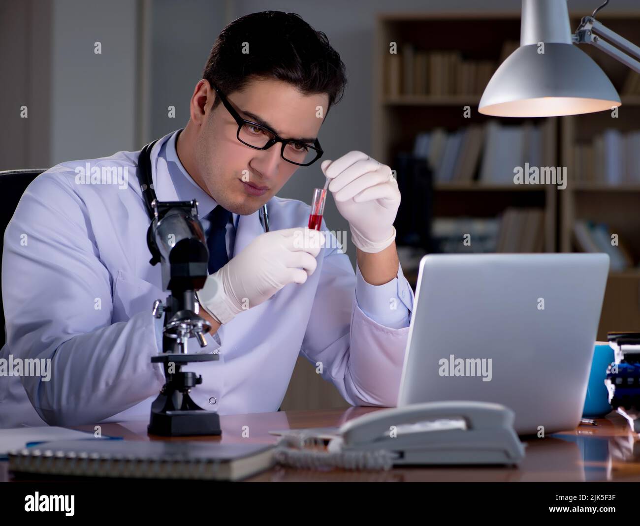 The young doctor working late in the office Stock Photo - Alamy