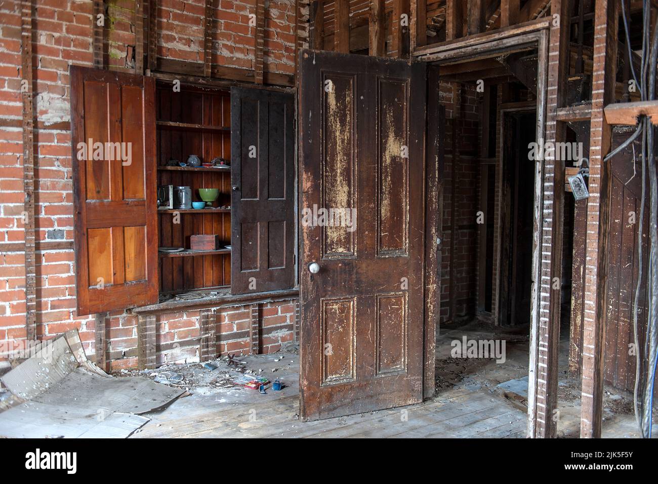 interior skeleton of an abandoned farm house with dusty dishes in open ...