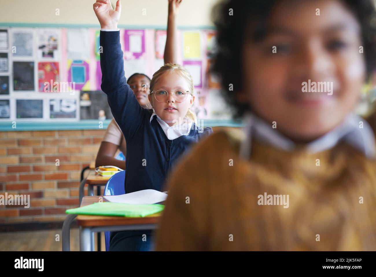 I know the answer. a diverse group of children sitting in their school ...