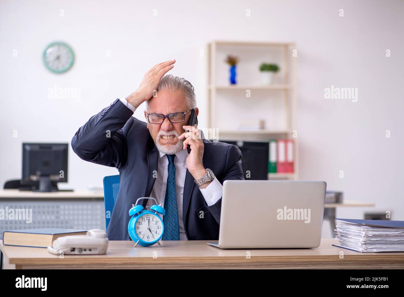 Old businessman employee in time management concept Stock Photo - Alamy