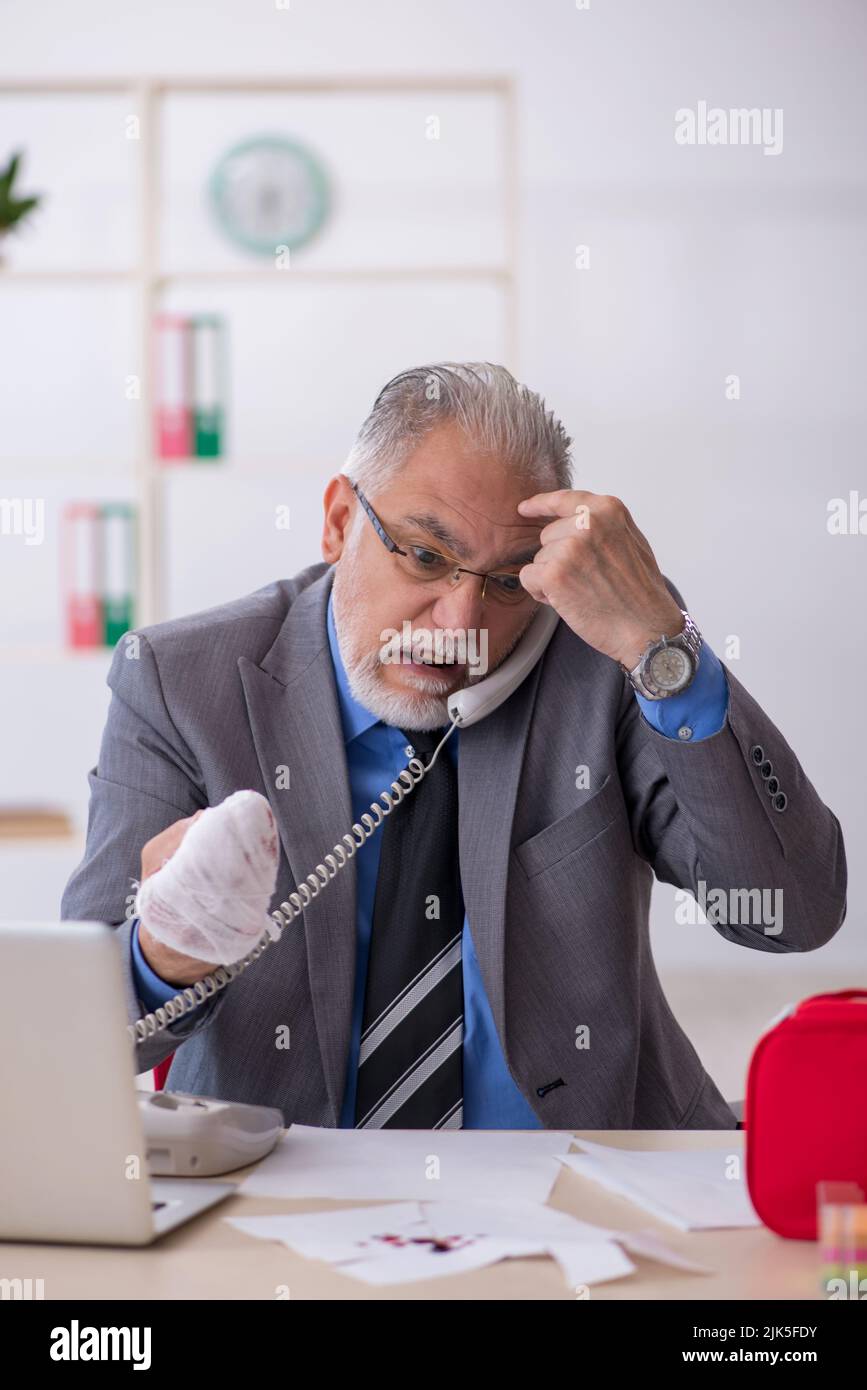Old businessman employee cutting his hand at workplace Stock Photo - Alamy
