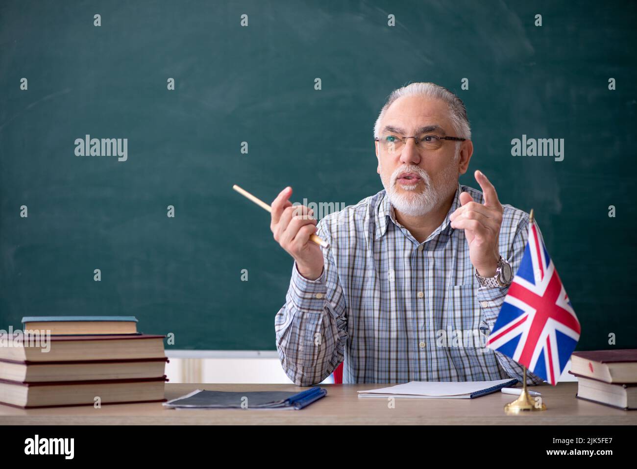 Aged english language teacher in the classroom Stock Photo - Alamy