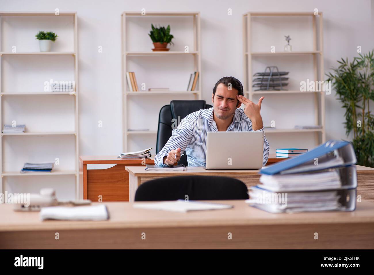 Young businessman employee unhappy with excessive work Stock Photo - Alamy