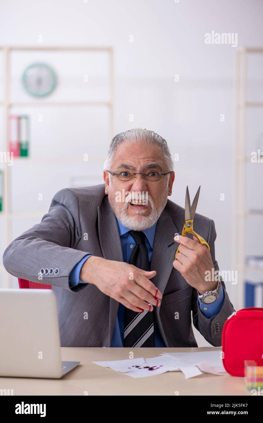 Old businessman employee cutting his hand at workplace Stock Photo - Alamy