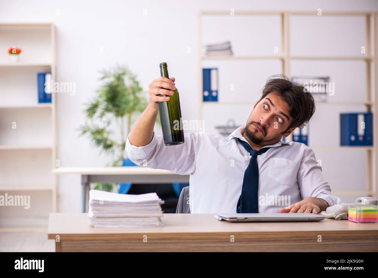 Male alcohol addicted employee sitting in the office Stock Photo - Alamy