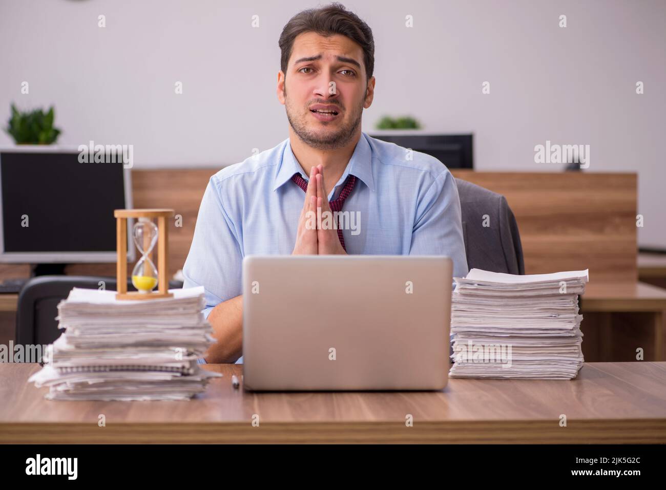 Young businessman employee unhappy with excessive work in the office ...