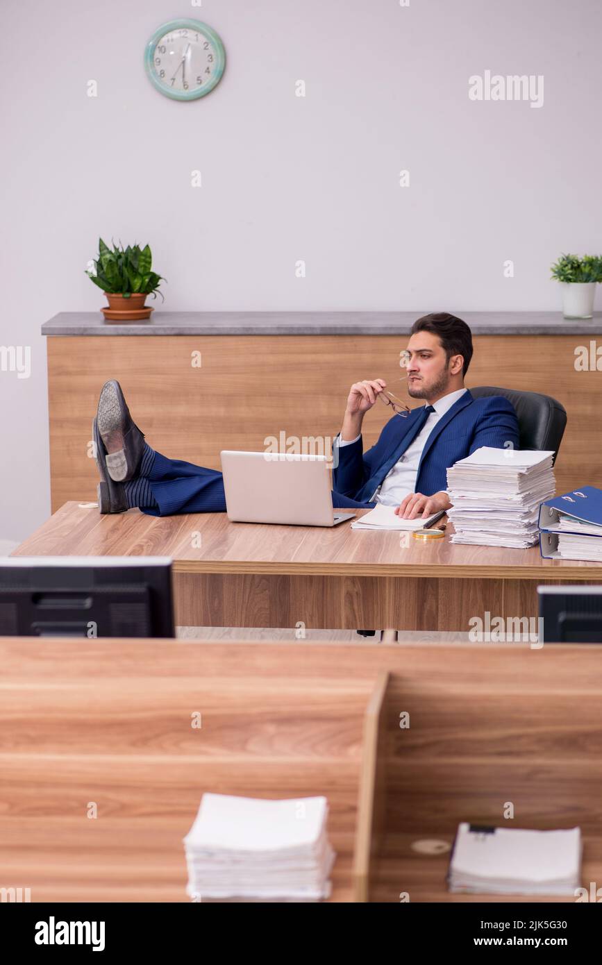 Young male employee sitting at workplace Stock Photo - Alamy