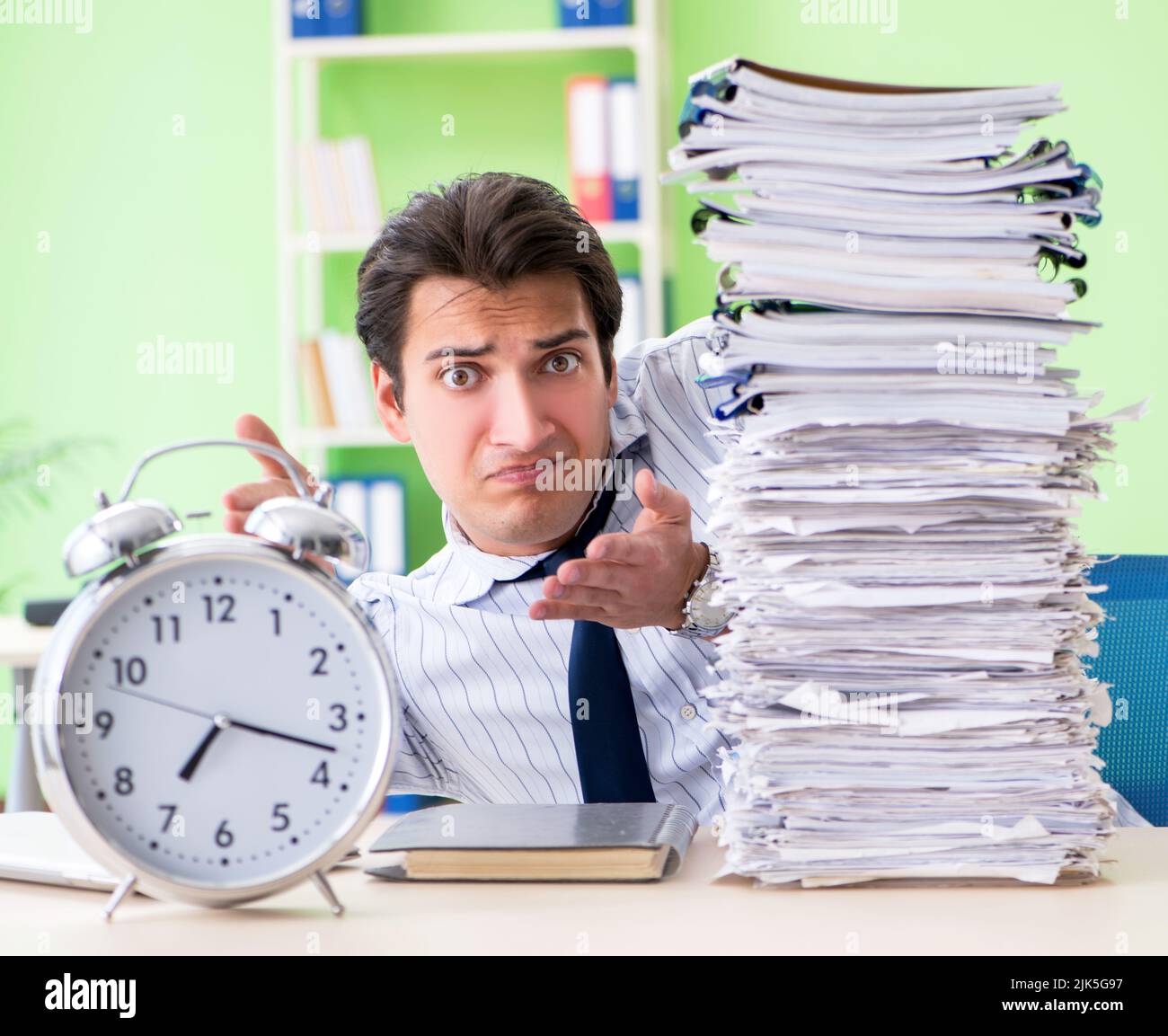 The businessman having problems with paperwork and workload Stock Photo ...