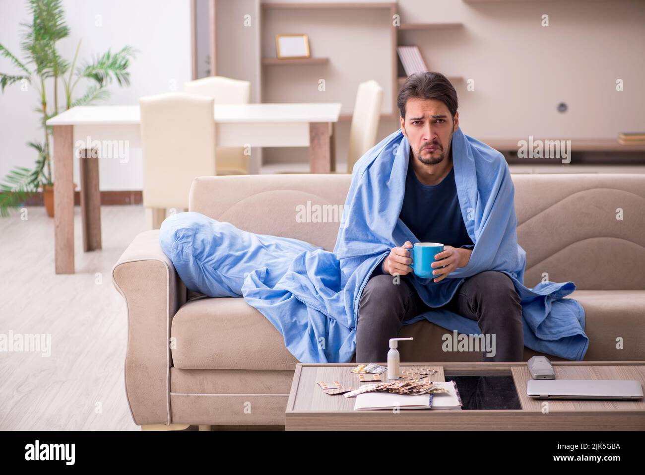 Young man feeling bad at home during pandemic Stock Photo - Alamy