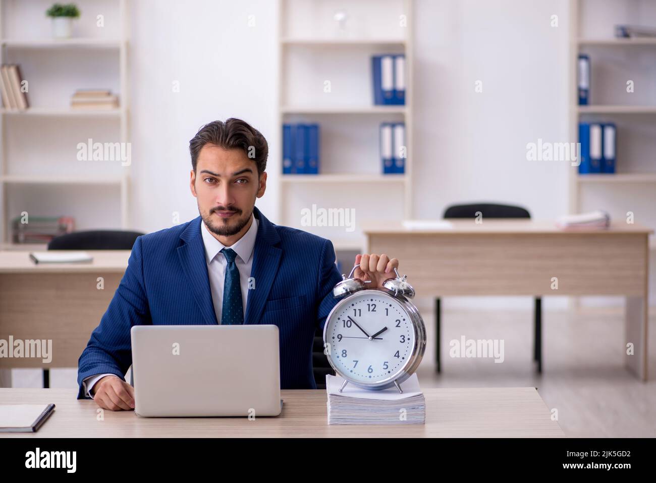 Young businessman employee in time management concept Stock Photo - Alamy