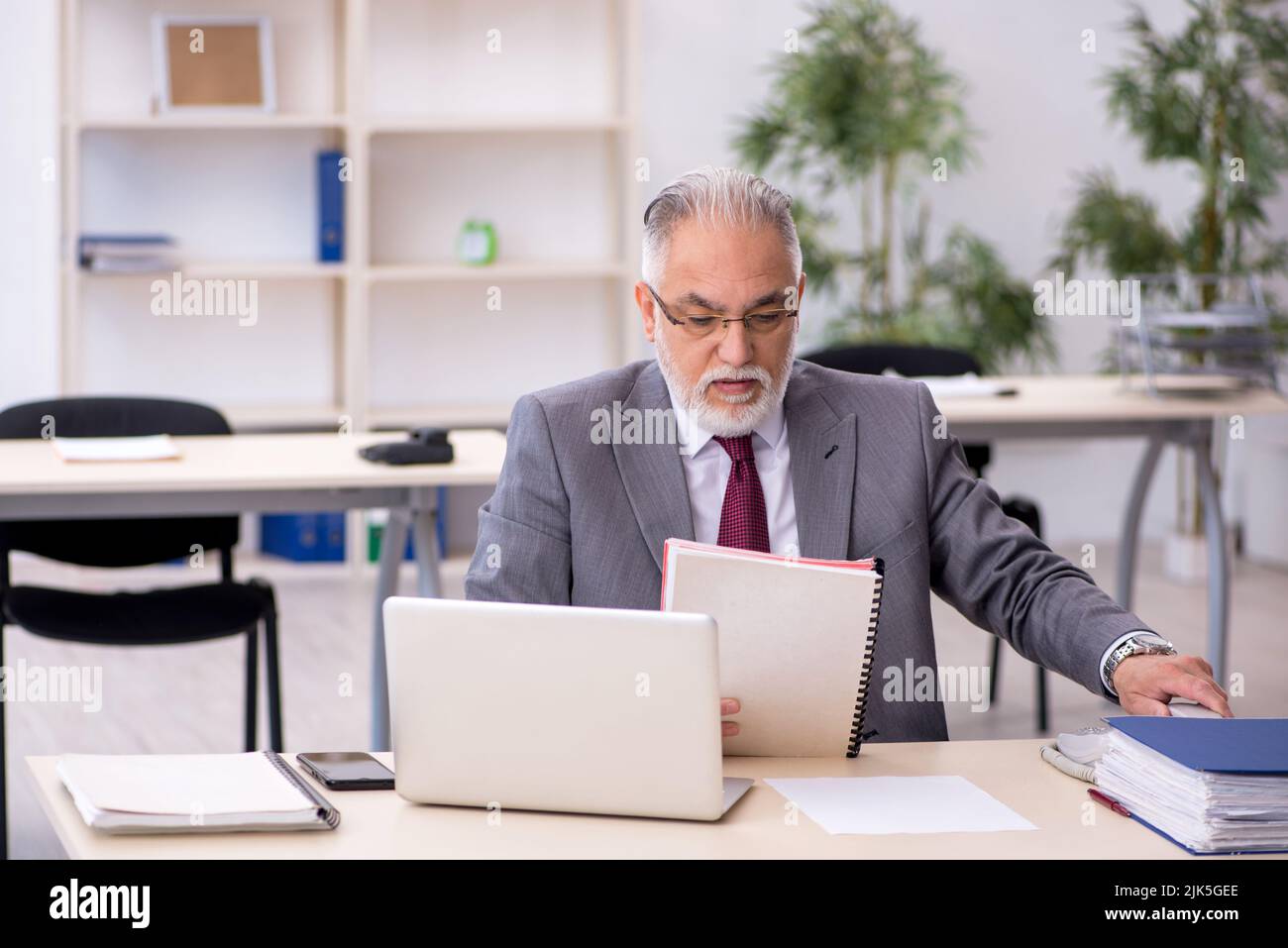 Old employee working in the office Stock Photo - Alamy