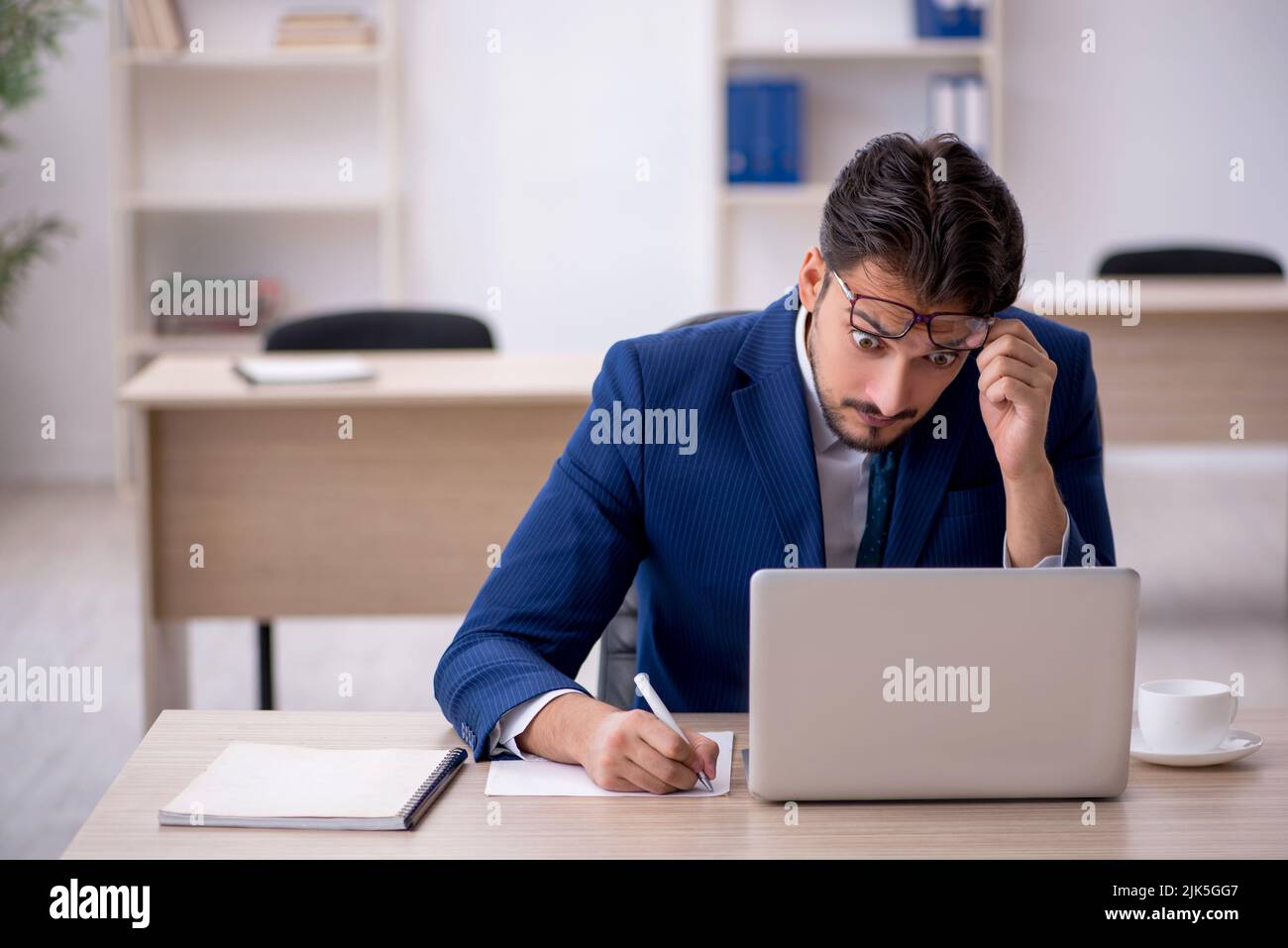 Young businessman employee sitting at workplace Stock Photo - Alamy