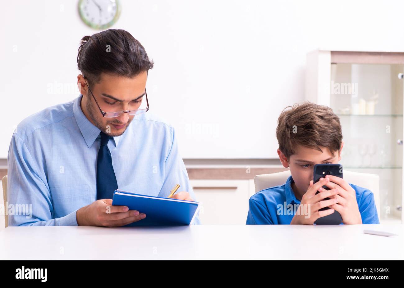 The busy father helping his son to prepare for exam Stock Photo - Alamy