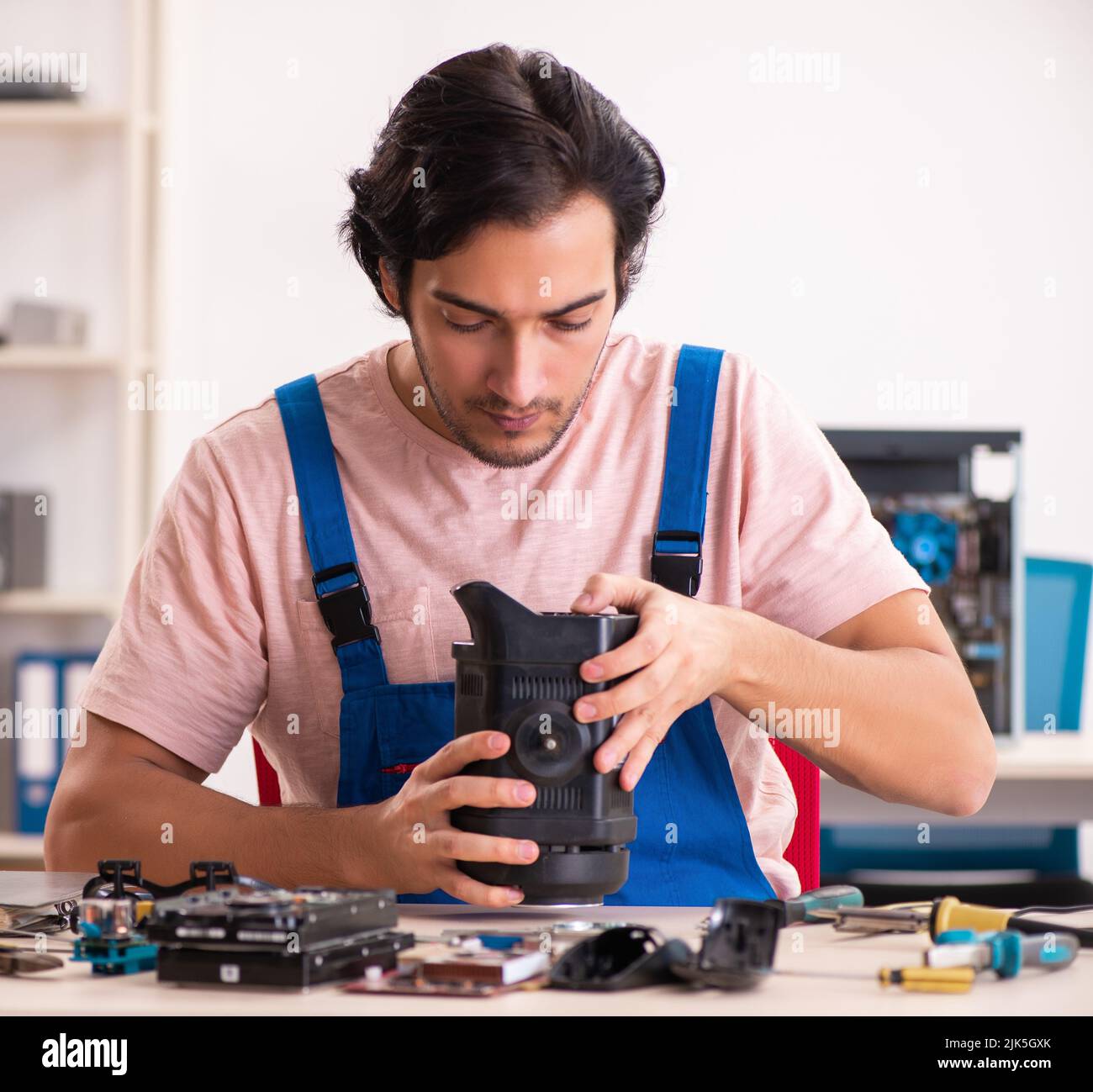 Young male contractor repairing computer Stock Photo - Alamy