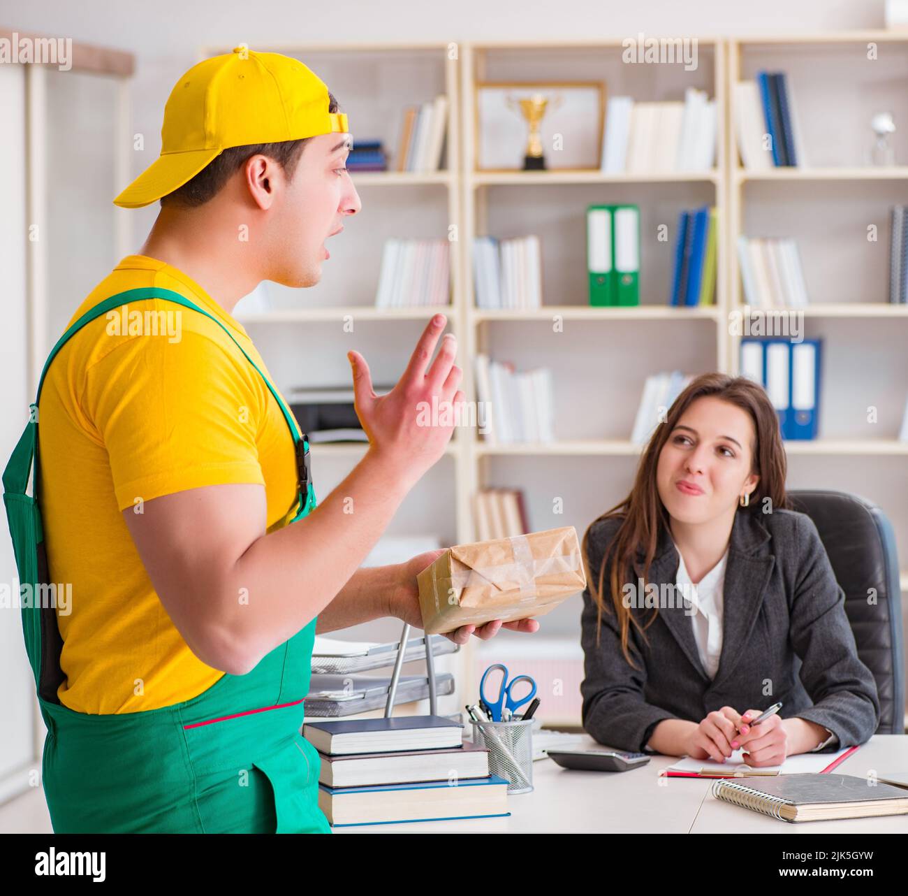 The postman delivering parcel to the office Stock Photo - Alamy
