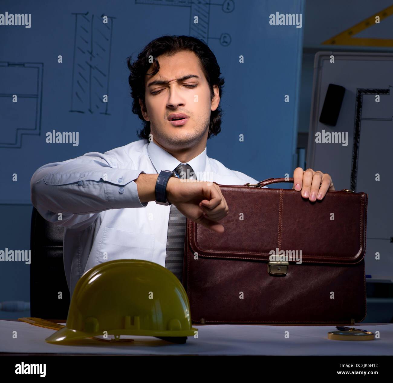 Young construction architect working on project at night Stock Photo ...