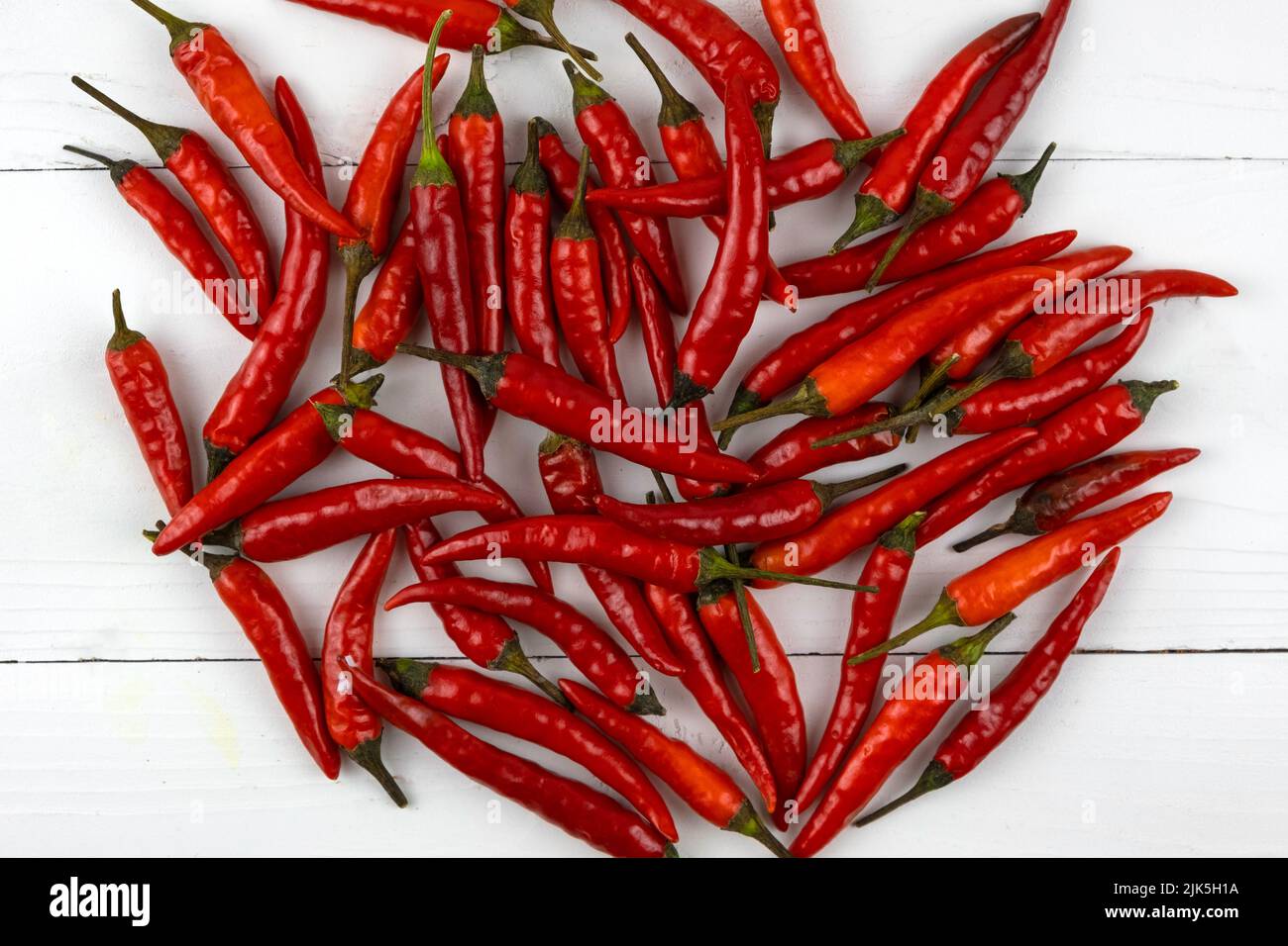 Red chilli pepper in the tray on a white table. View from above Stock ...