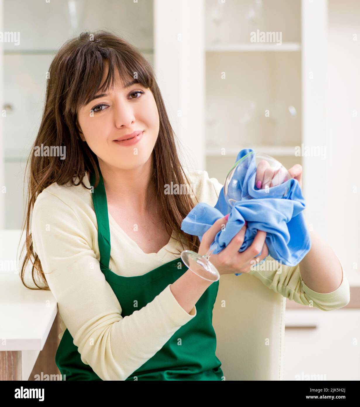 The young woman cleaning glasses at home Stock Photo - Alamy