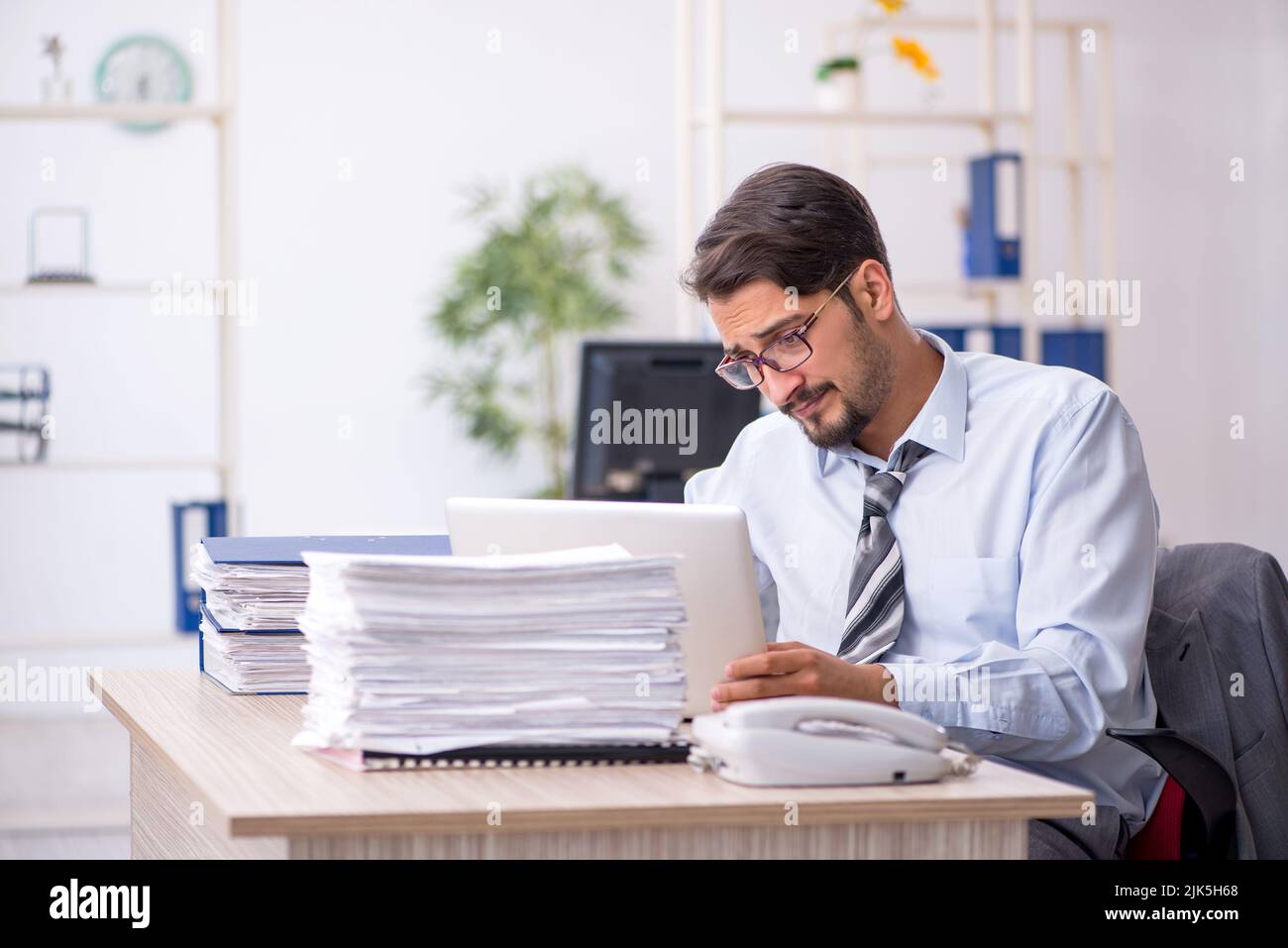 Young male employee working in the office Stock Photo - Alamy