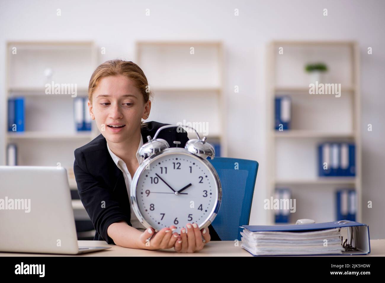 Female employee in time management concept Stock Photo - Alamy