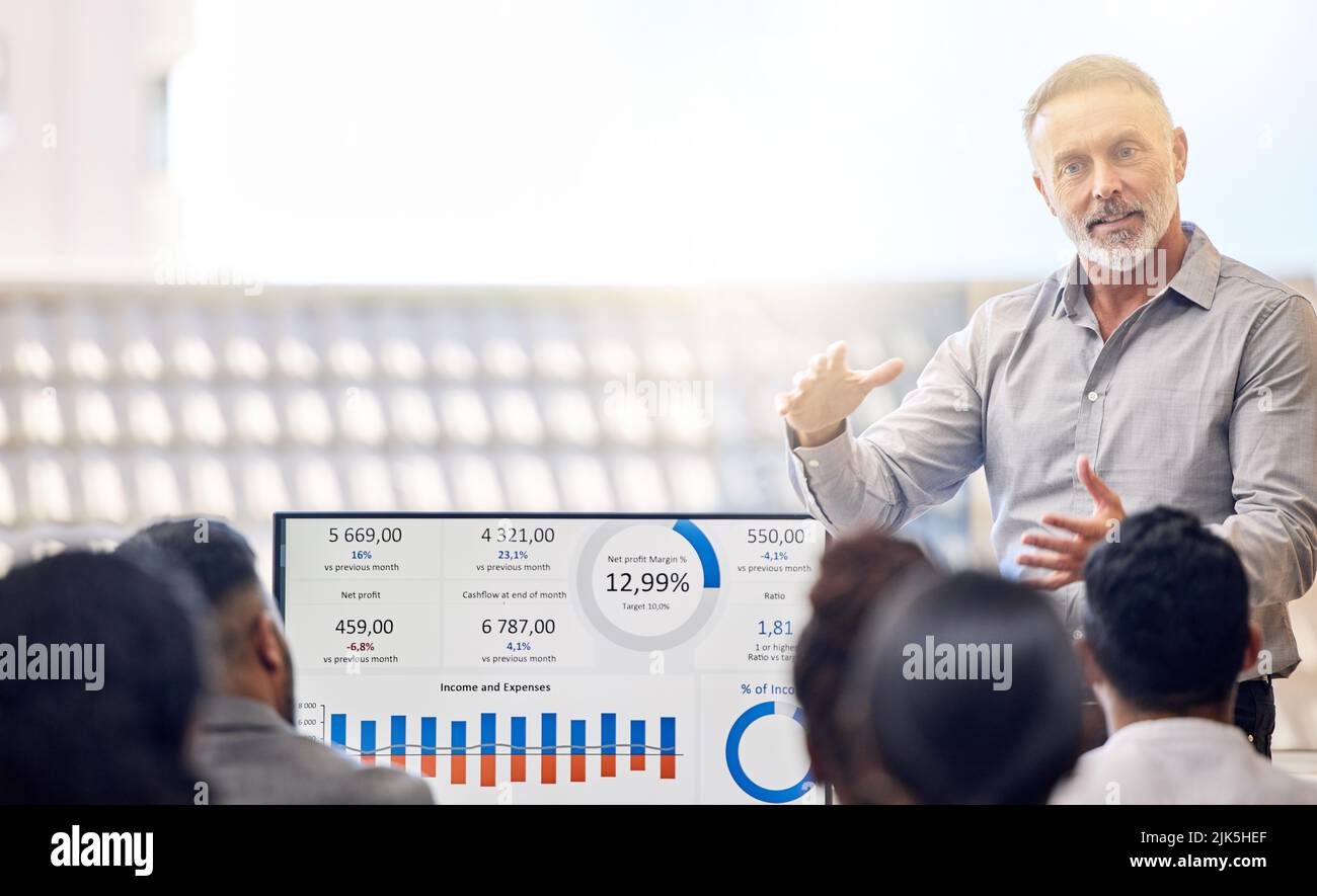 Explaining the ins and outs. a handsome mature businessman giving a ...