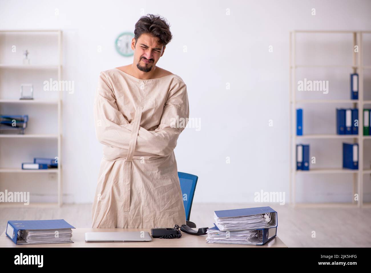 Crazy young male employee in straitjacket at the office Stock Photo - Alamy