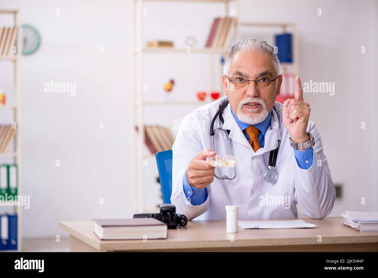 Old doctor working in the clinic Stock Photo - Alamy