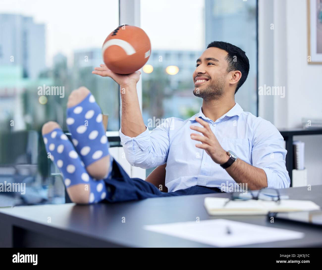 Hang on to your inner child. a playful businessman throwing a ball at ...