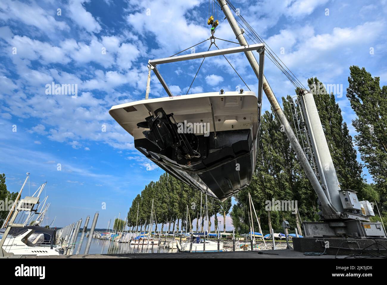 Moos Am Bodensee, Germany. 28th July, 2022. A crane hoists a motorboat ...