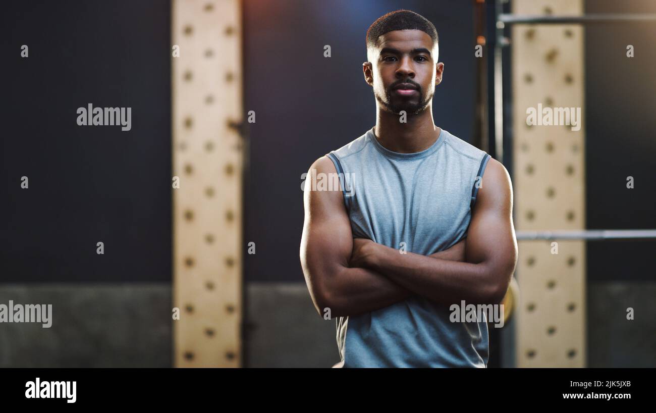 Weakness has no place here. Portrait of a muscular young man standing ...