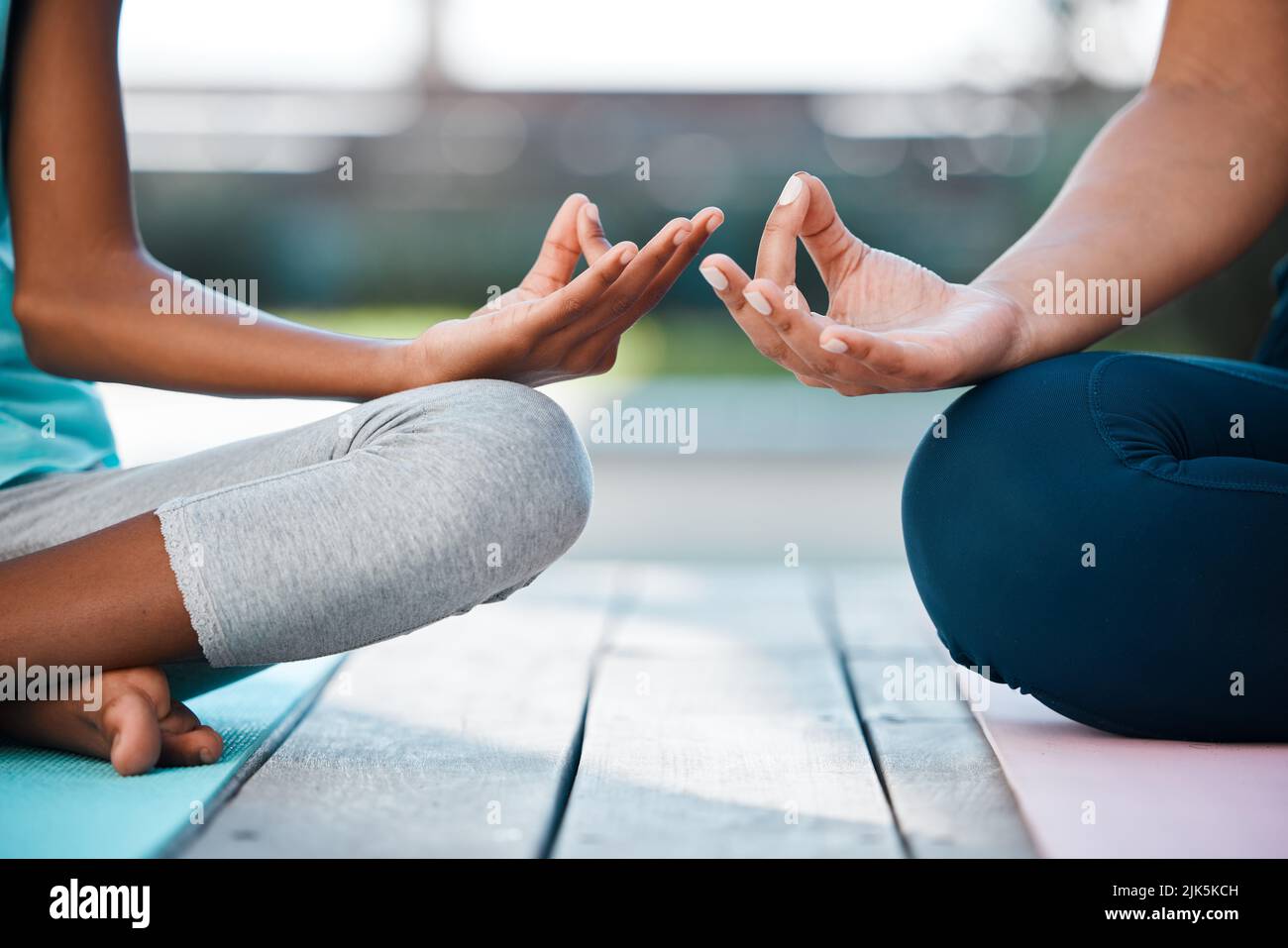 Finding peace from within. two unrecognizable people meditating at home ...