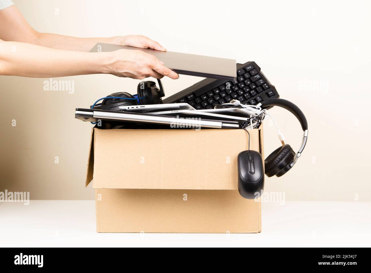 Woman hands put old laptop computer in cardboard box full used ...